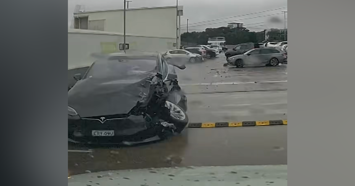 Out-of-control Tesla crashes into cars, plunges off carpark roof ...